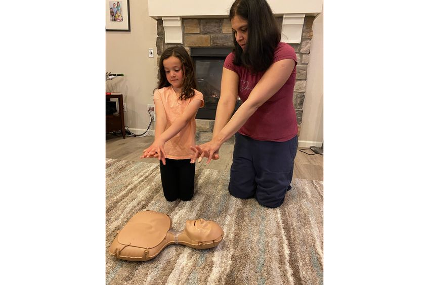 Photo | Mom showing daughter proper CPR form | American Heart Association