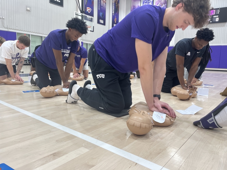 Photo | TCU Basketball players practice CPR | American Heart Association